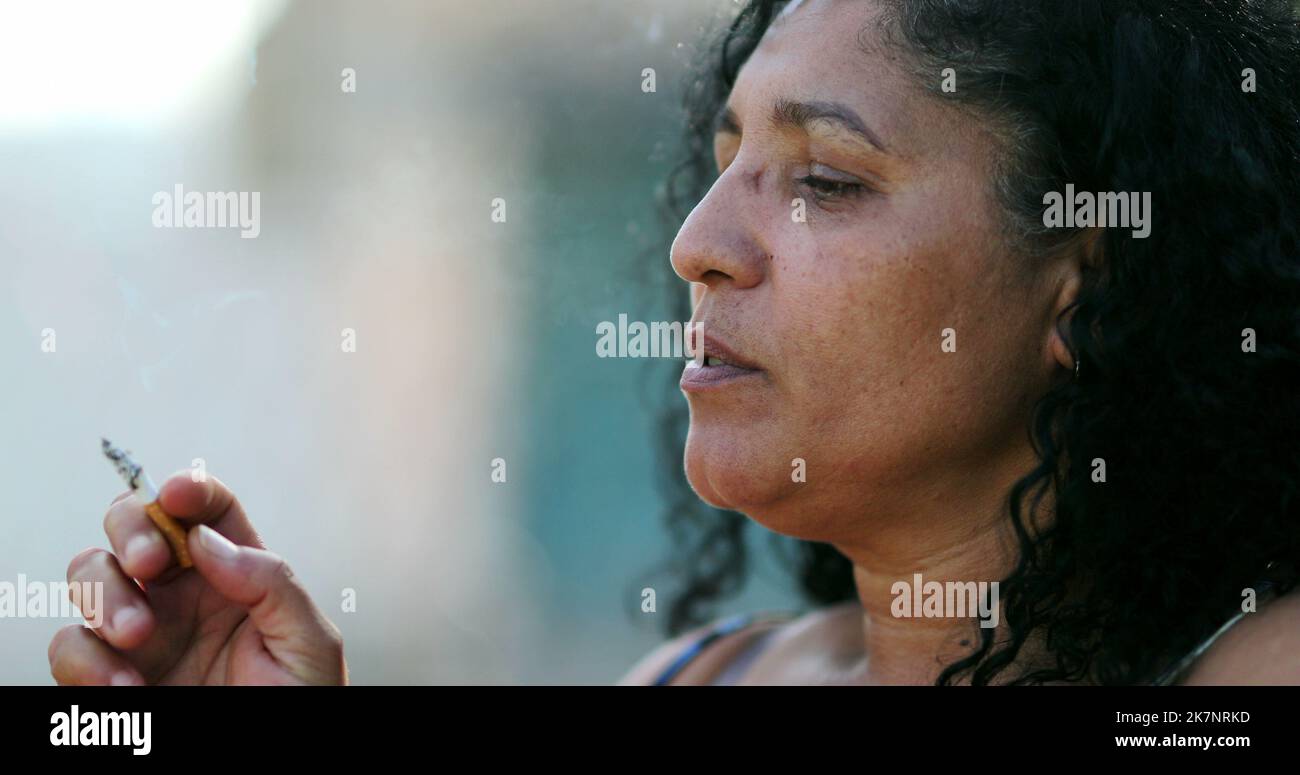 Hispanic anxious woman smoking cigarette Stock Photo - Alamy
