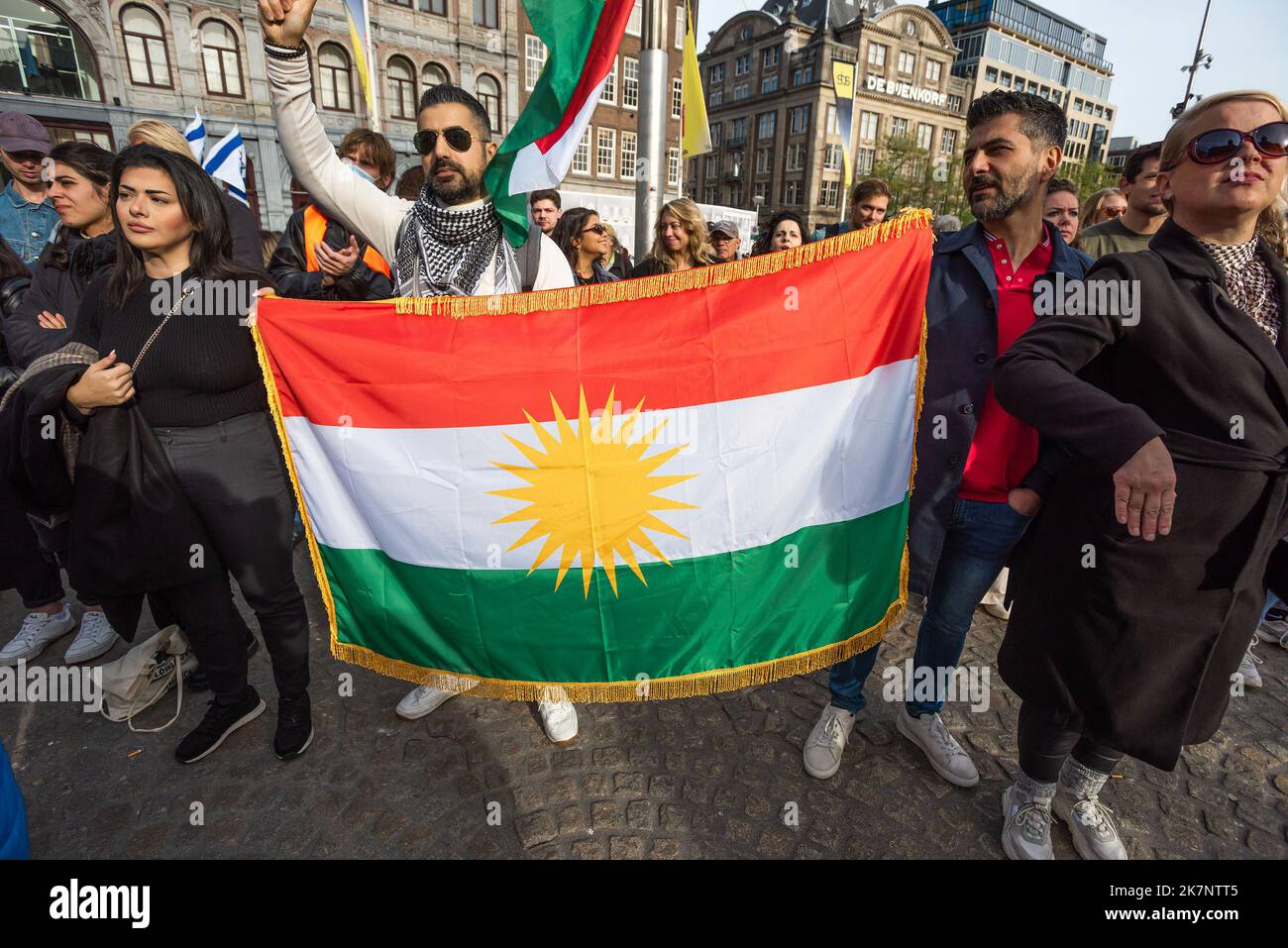 Protesters hold a large Iranian flag, during the ‘Woman Life Freedom ...