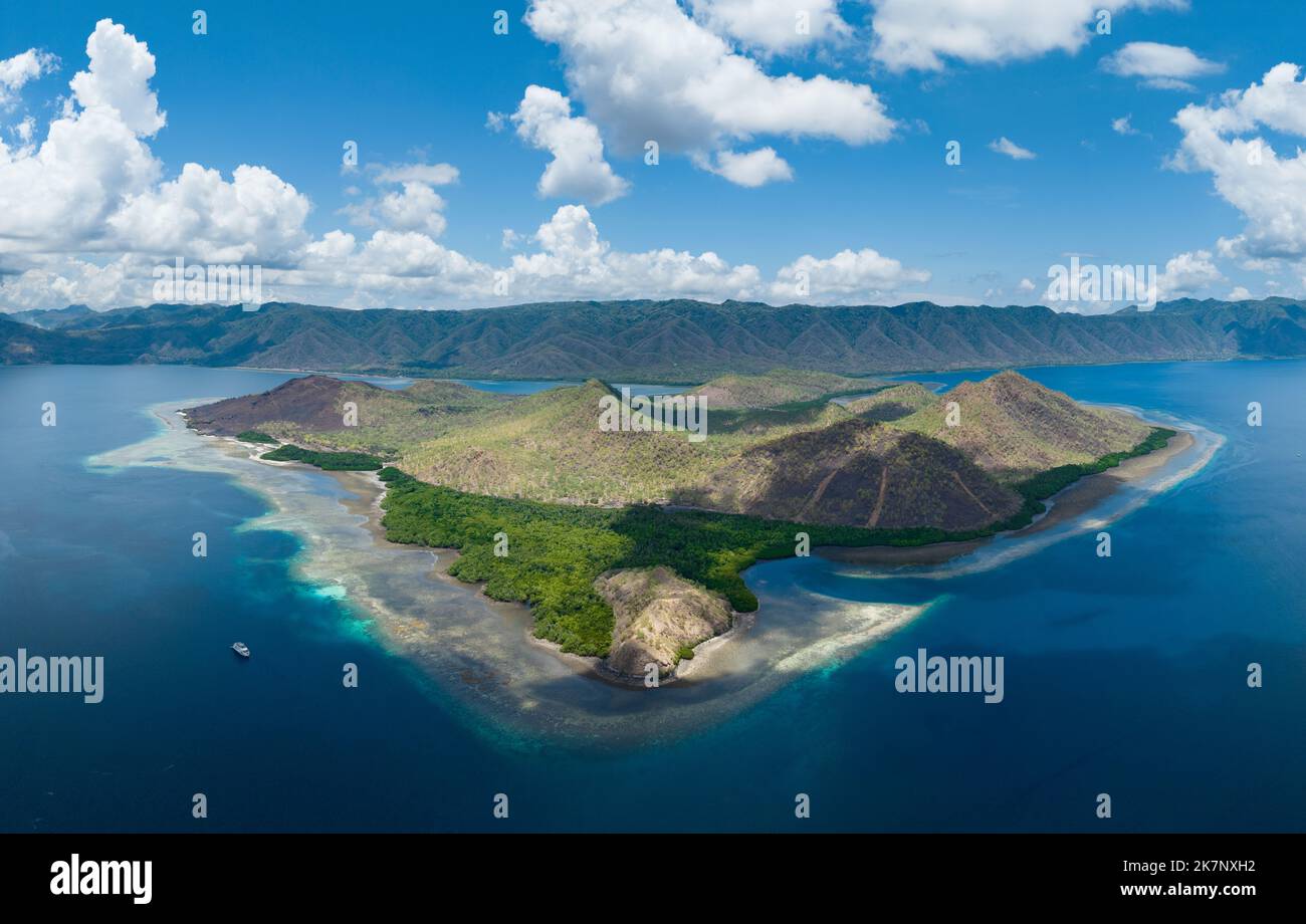 A beautiful coral reef fringes a remote island in the Lesser Sunda ...