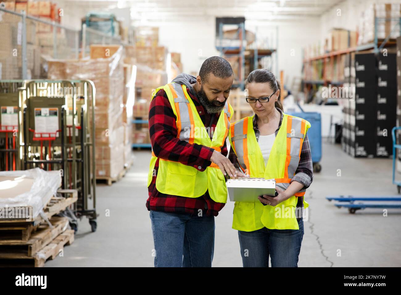 Warehouse workers with clipboard talking Stock Photo - Alamy