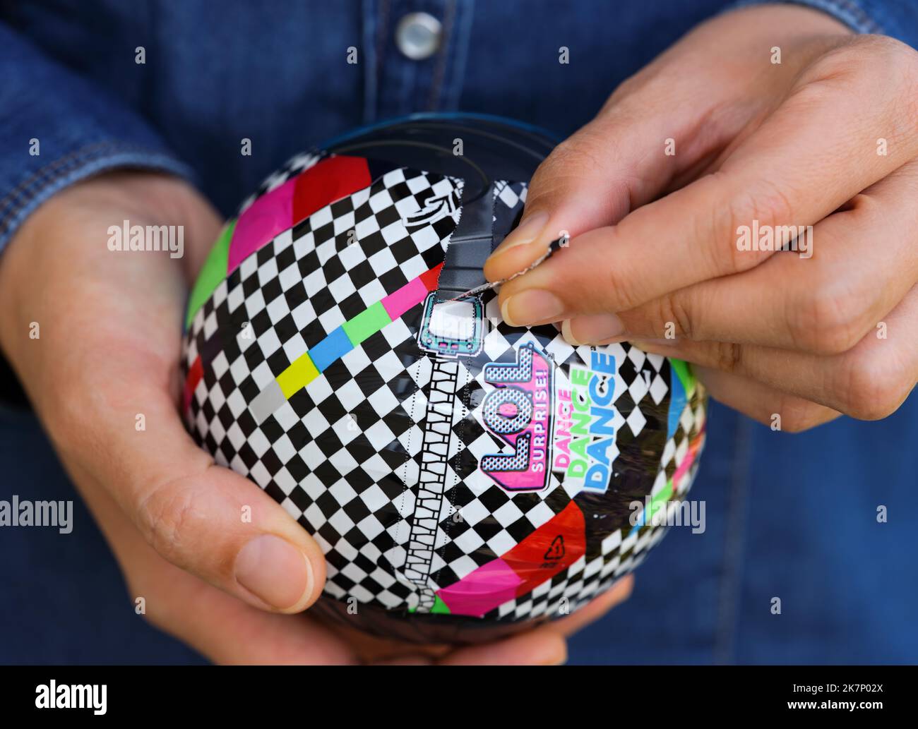 Tambov, Russian Federation - October 02, 2022 A woman peeling packaging ...