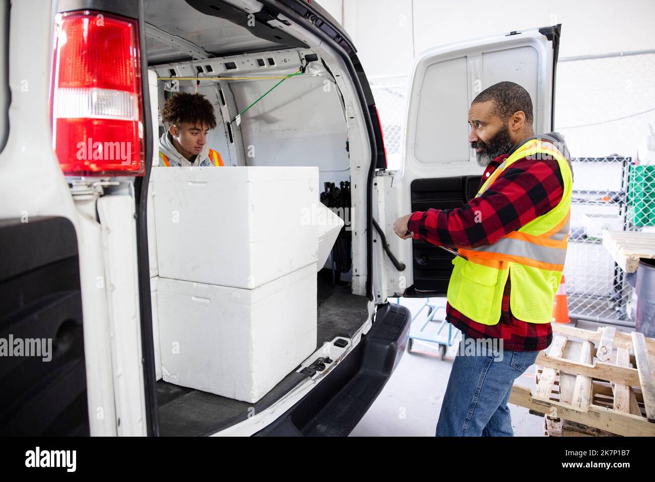 Male warehouse workers loading boxes into van Stock Photo - Alamy