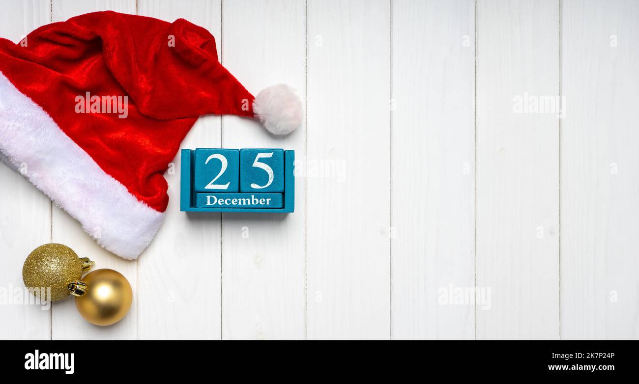 Red Santa Claus hat, two golden balls and blue perpetual calendar with ...