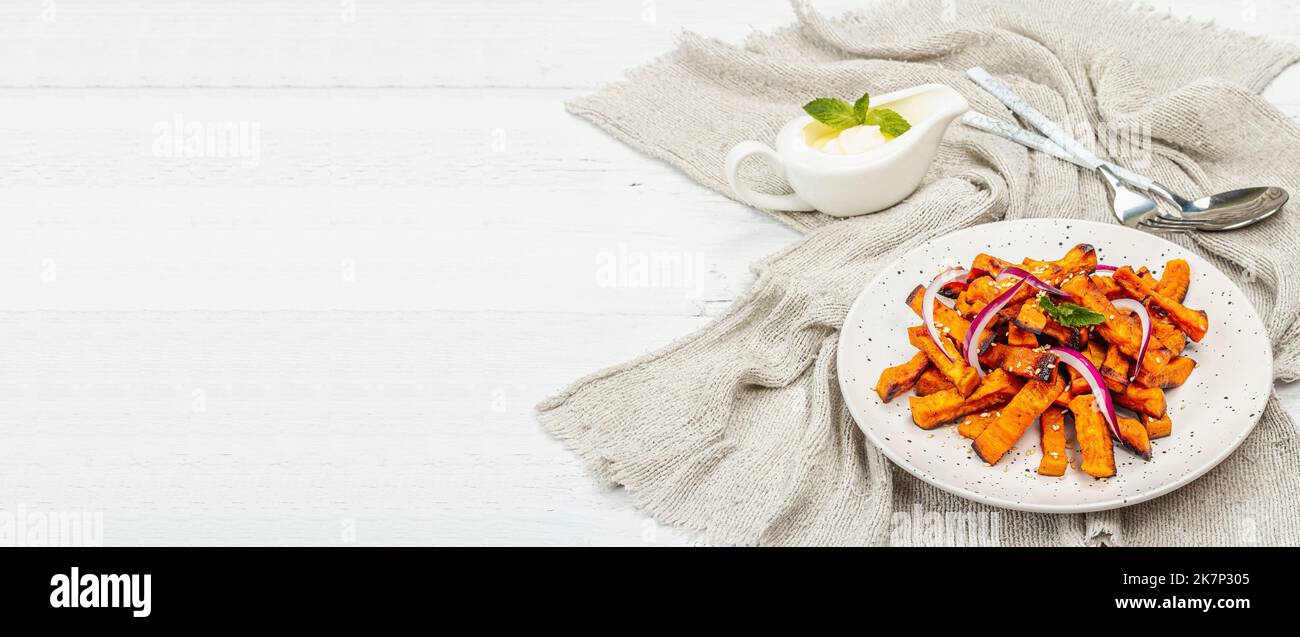 Baked organic batata fries with spices and sauce. Sweet vegetable ...