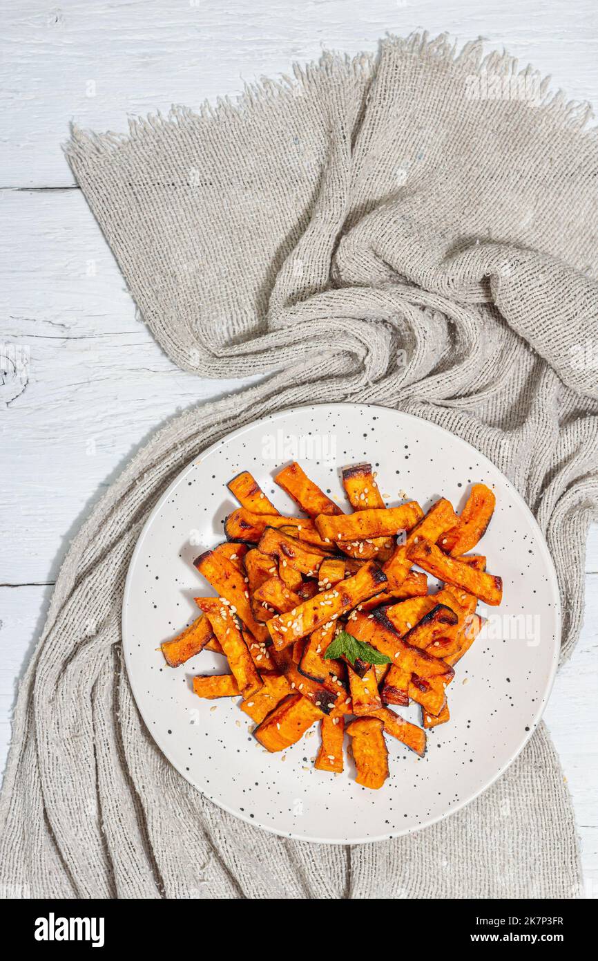 Baked organic batata fries with spices and sauce. Sweet vegetable ...