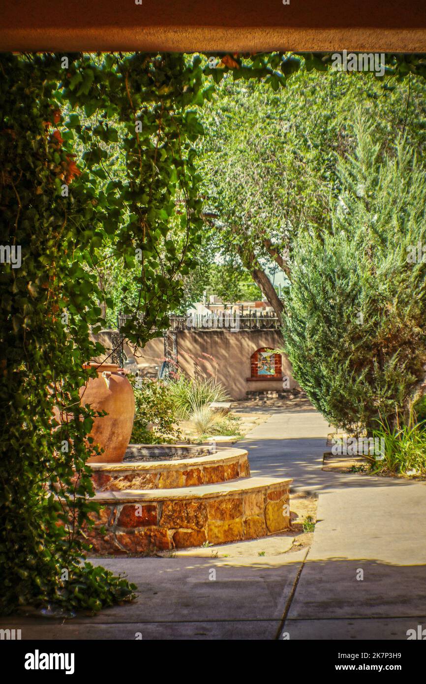 Rustic Santa Fe courtyard with fountain framed by adobe doorway with ...