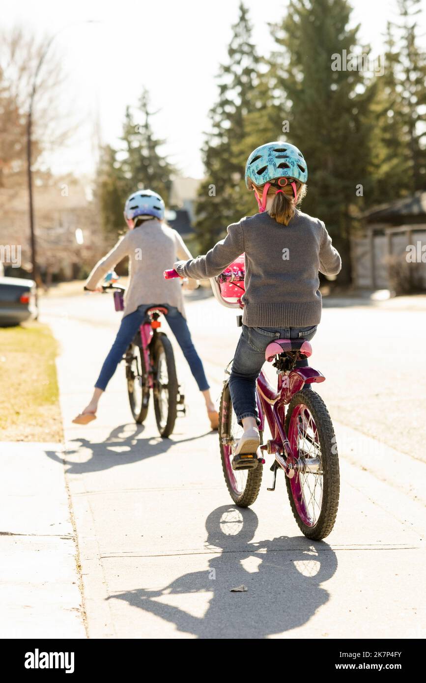 Rear view of sisters riding bicycle on walkway Stock Photo - Alamy Rear view of sisters riding bicycle on walkway Stock Photo - Alamy