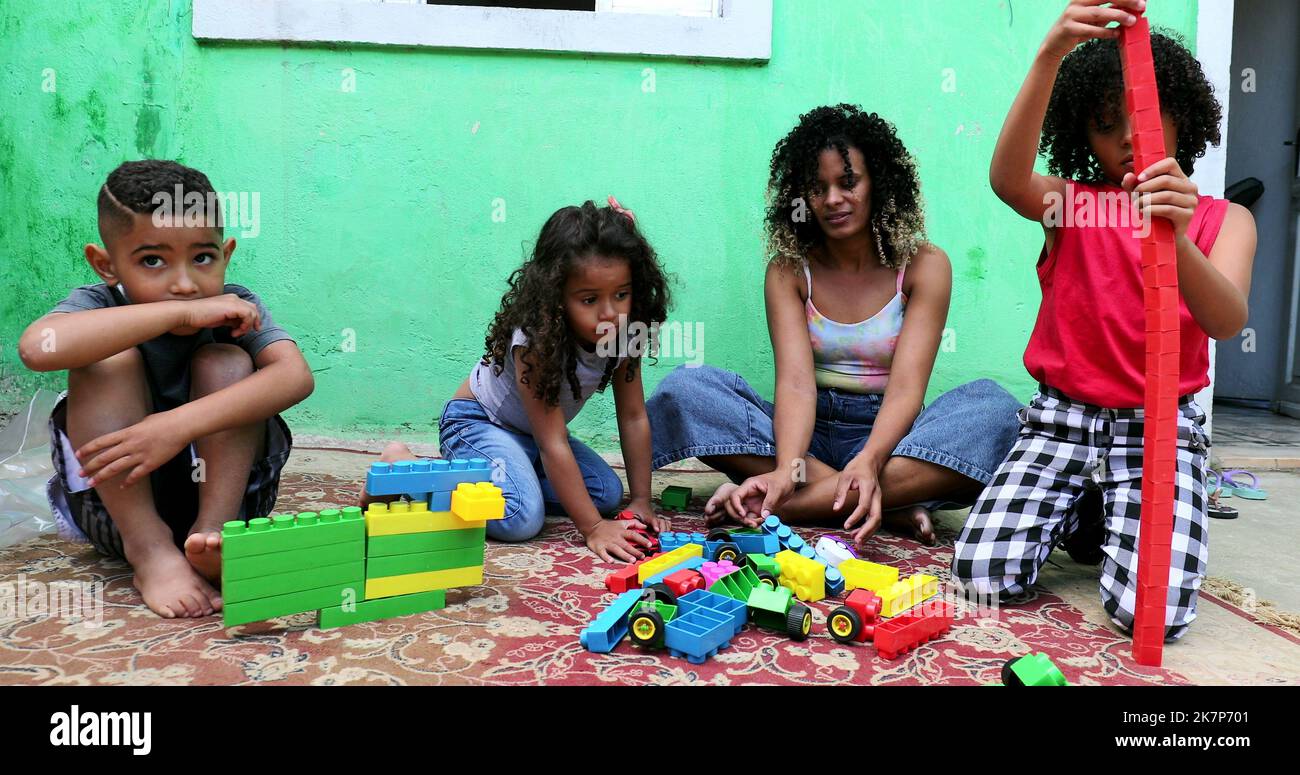 Latin Brazilian children playing outside next to mother Stock Photo - Alamy