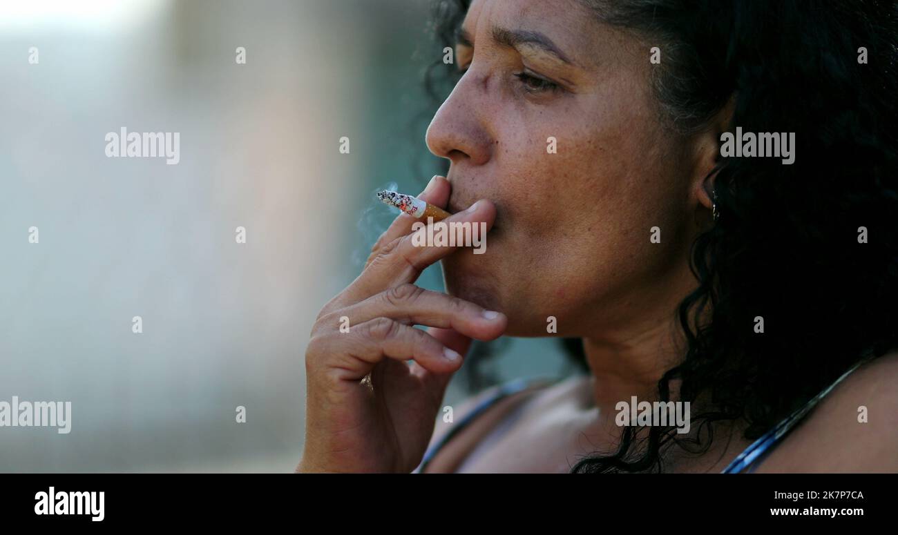 Hispanic anxious woman smoking cigarette Stock Photo - Alamy