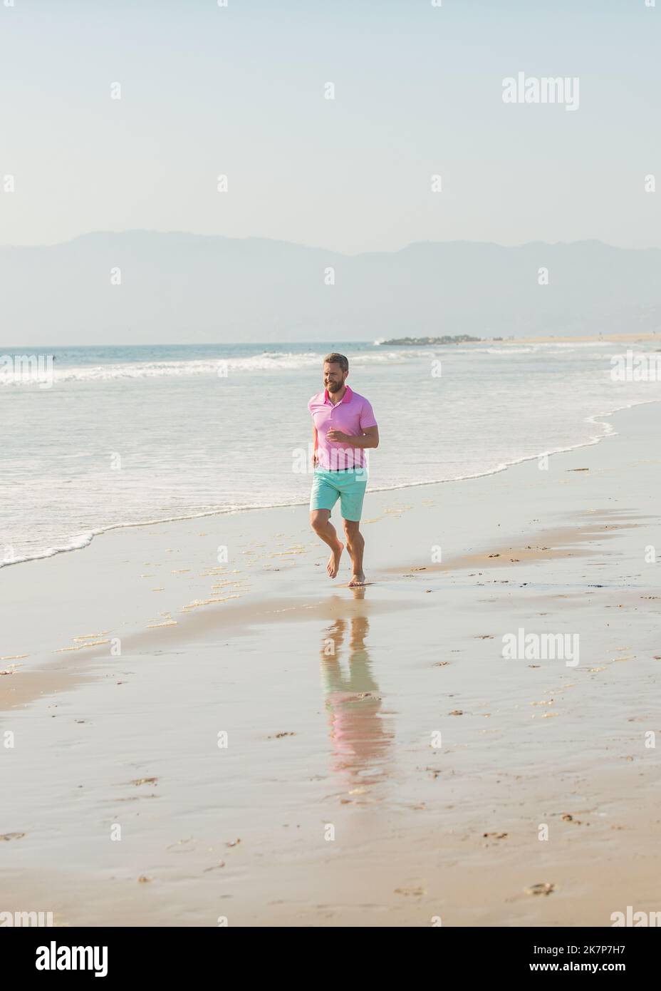 smiling sport athlete run fast to win in the ocean. morning workout ...