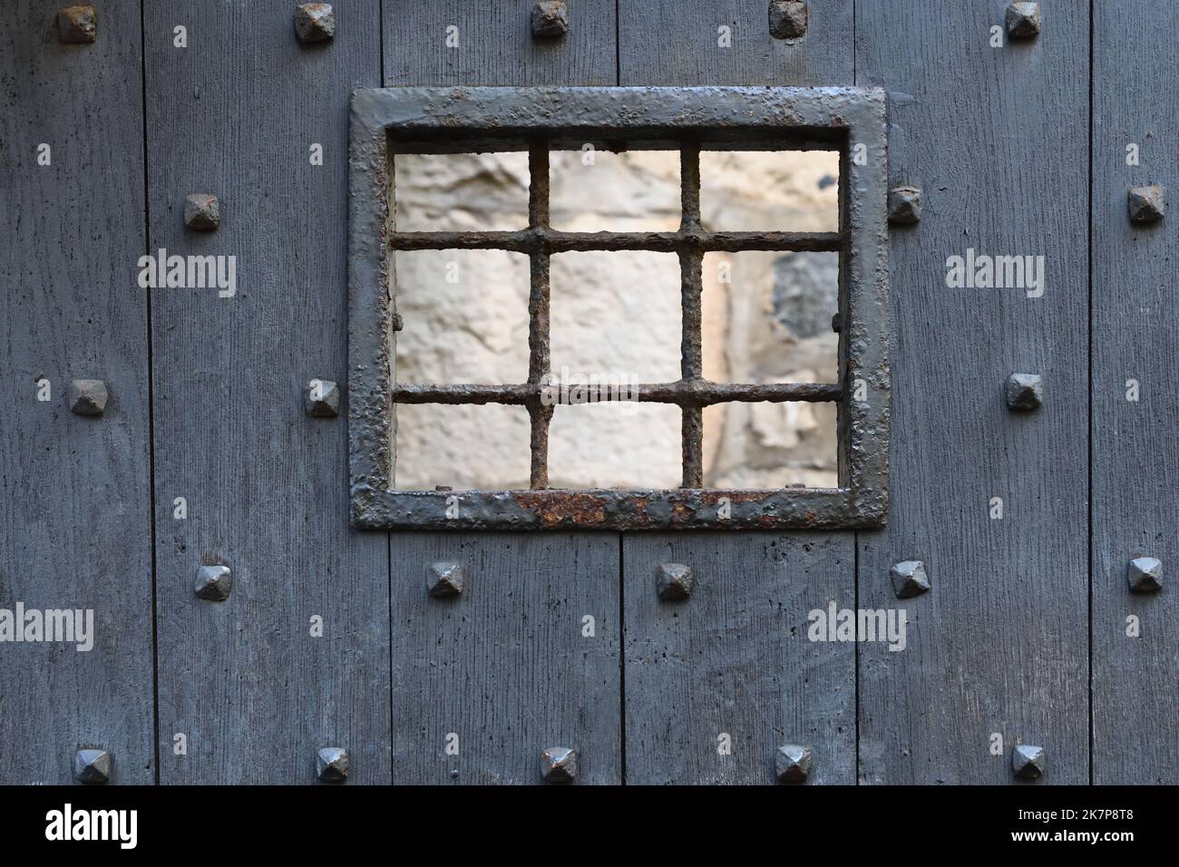 A wrought iron window in a fortified wooden door at the museum of ...