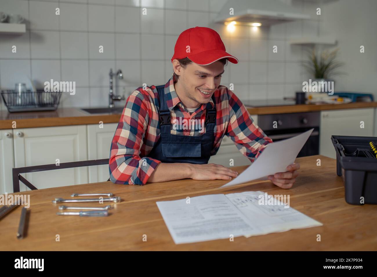 Cheerful repairman focused on perusing technical documentation Stock ...