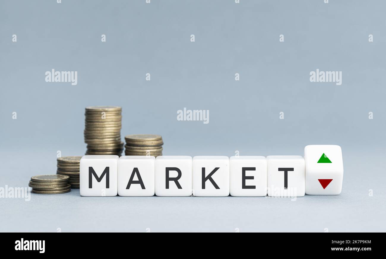 Market word and up and down arrows on block shape and coins stacked ...