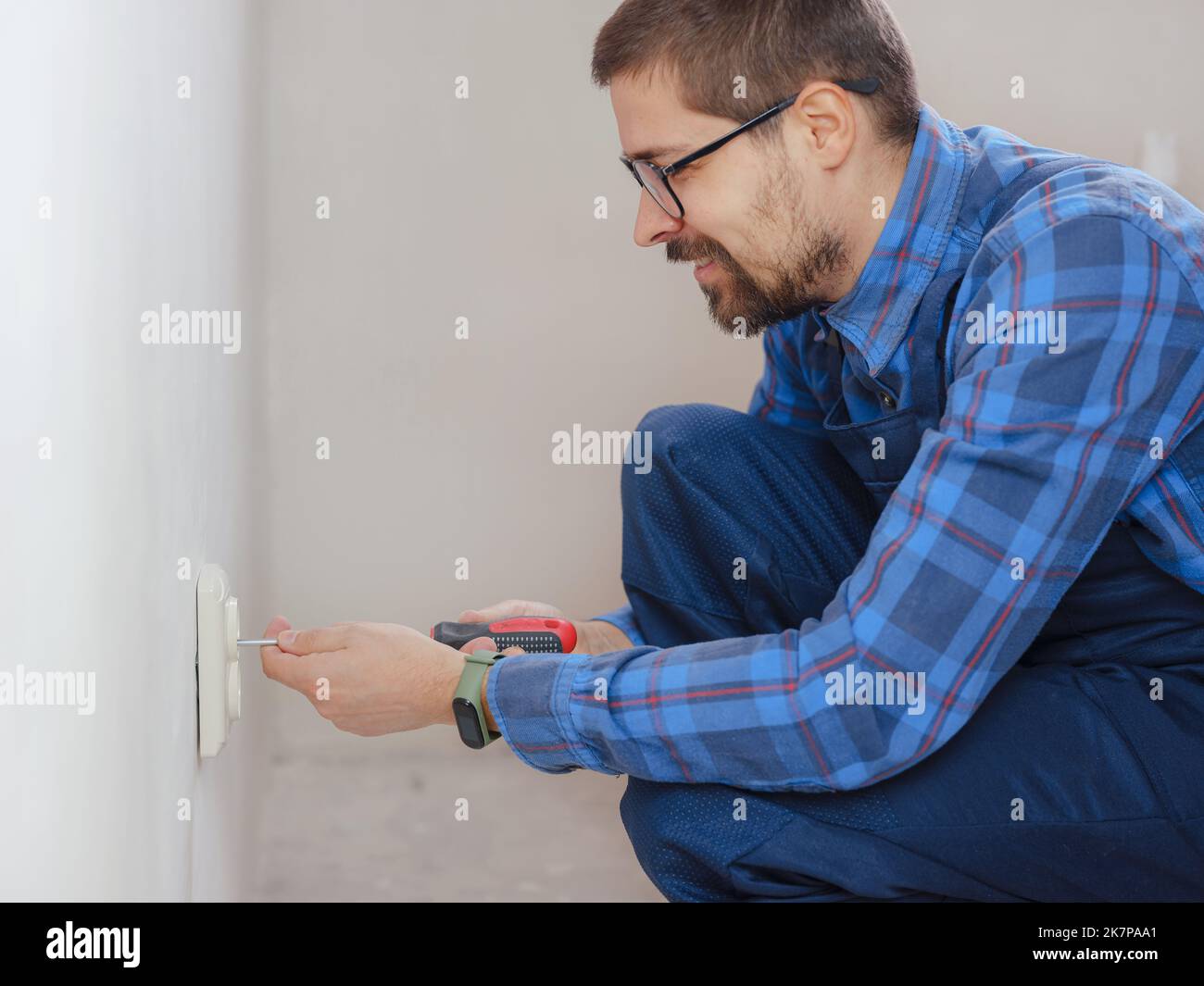 young man in blue work suit doing Repair apartment. Home renovation ...