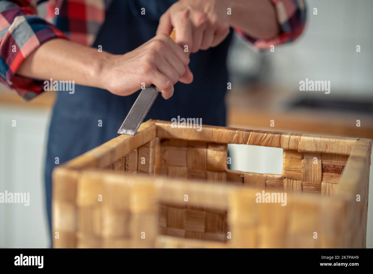 Carpenter cutting off the excess glue from the box edging Stock Photo ...