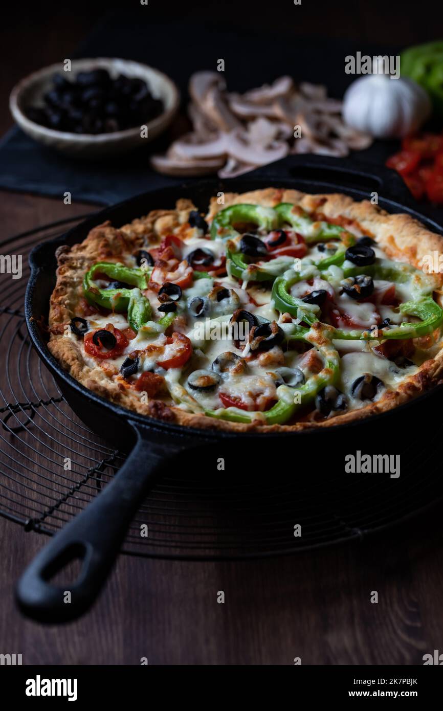 Large deluxe deep dish pan pizza against a dark background Stock Photo ...