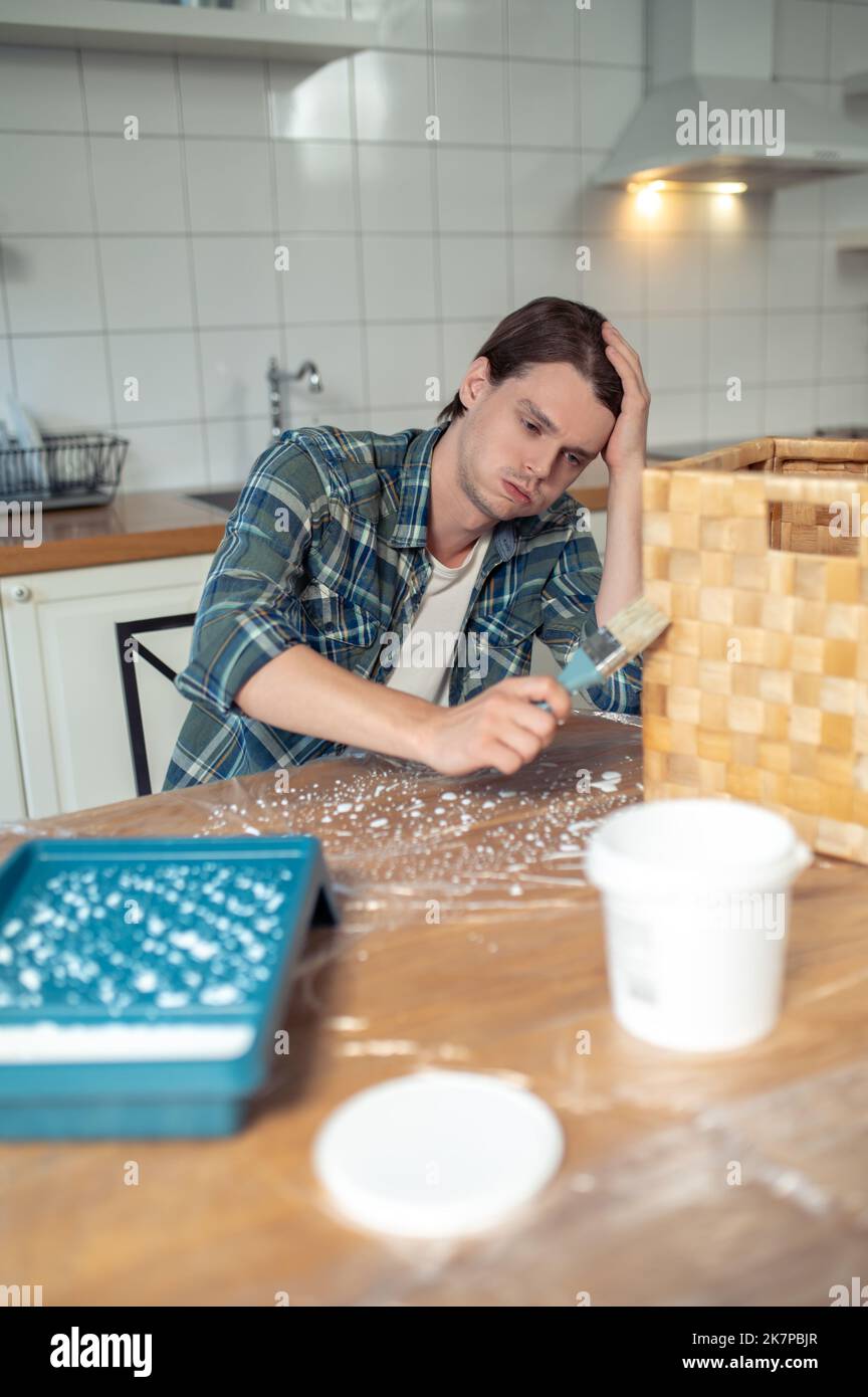Exhausted carpenter painting the box in the kitchen Stock Photo - Alamy