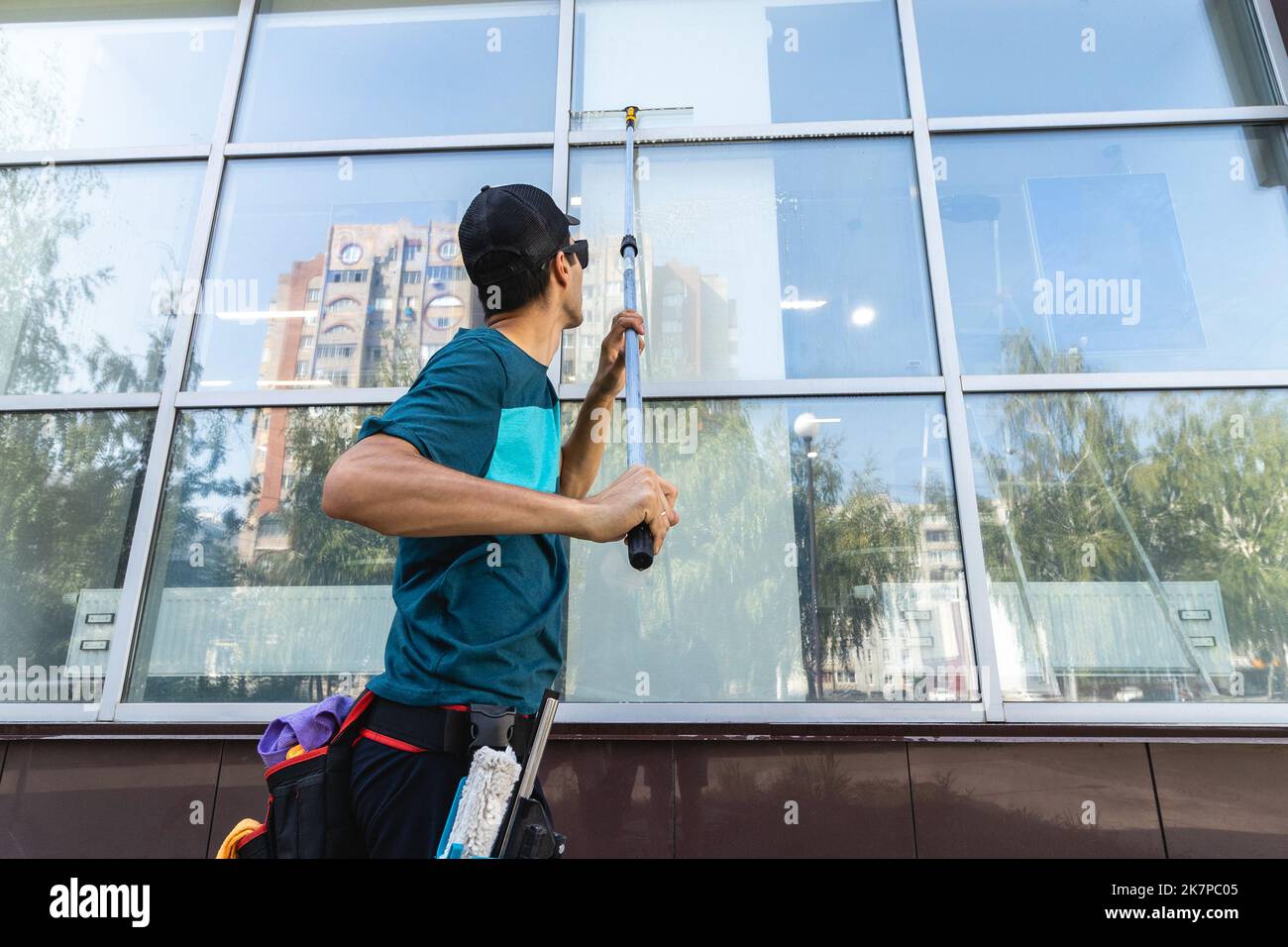 Male professional cleaning service worker in overalls cleans the ...