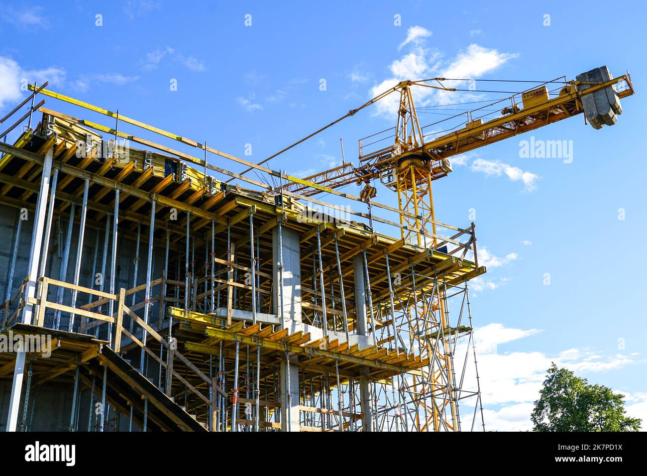 Yellow construction tower crane and concrete formwork with a folding ...