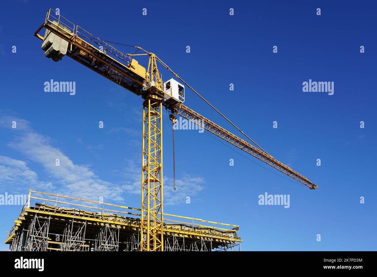 Yellow construction tower crane and concrete formwork with a folding ...