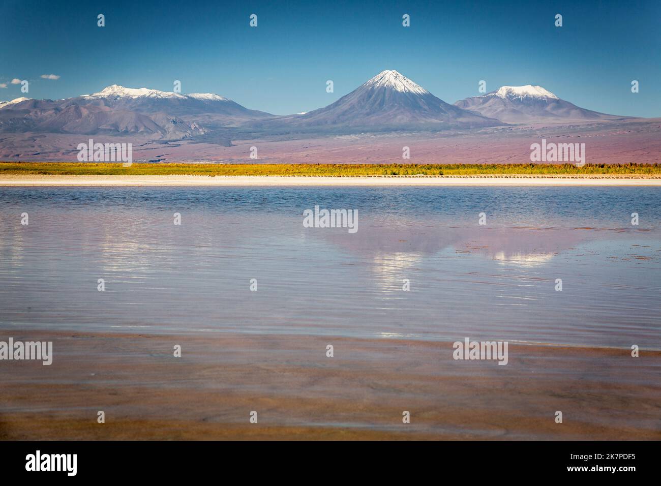 Volcanic landscape and salt lake reflection at sunset in Atacama Desert ...