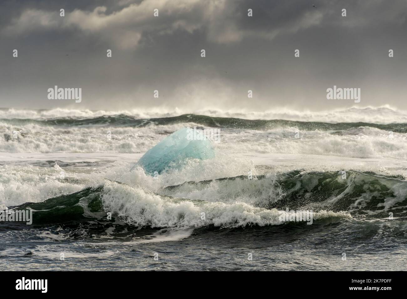 Blue ice growler being tumbled in the storm waves, Diamond Beach ...