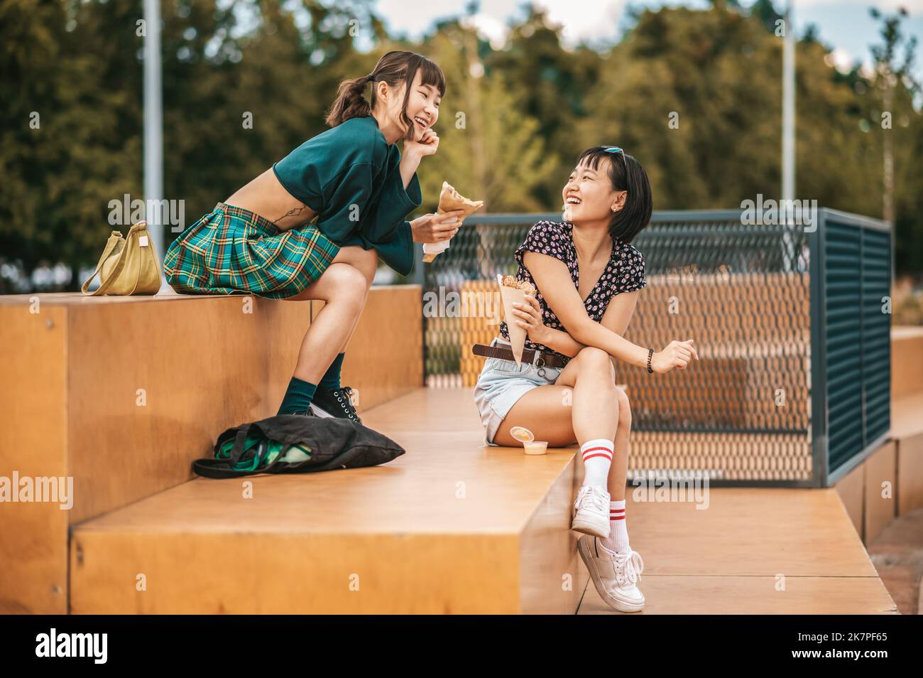 Enjoying the day. Two pretty girls spending time together and looking ...