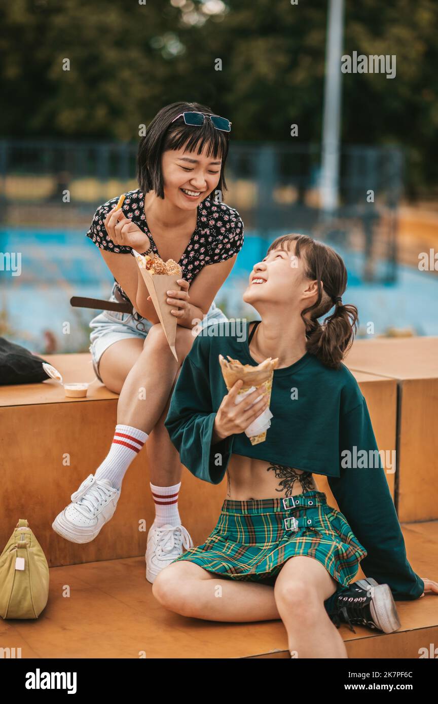 Enjoying the day. Two pretty girls spending time together and looking ...