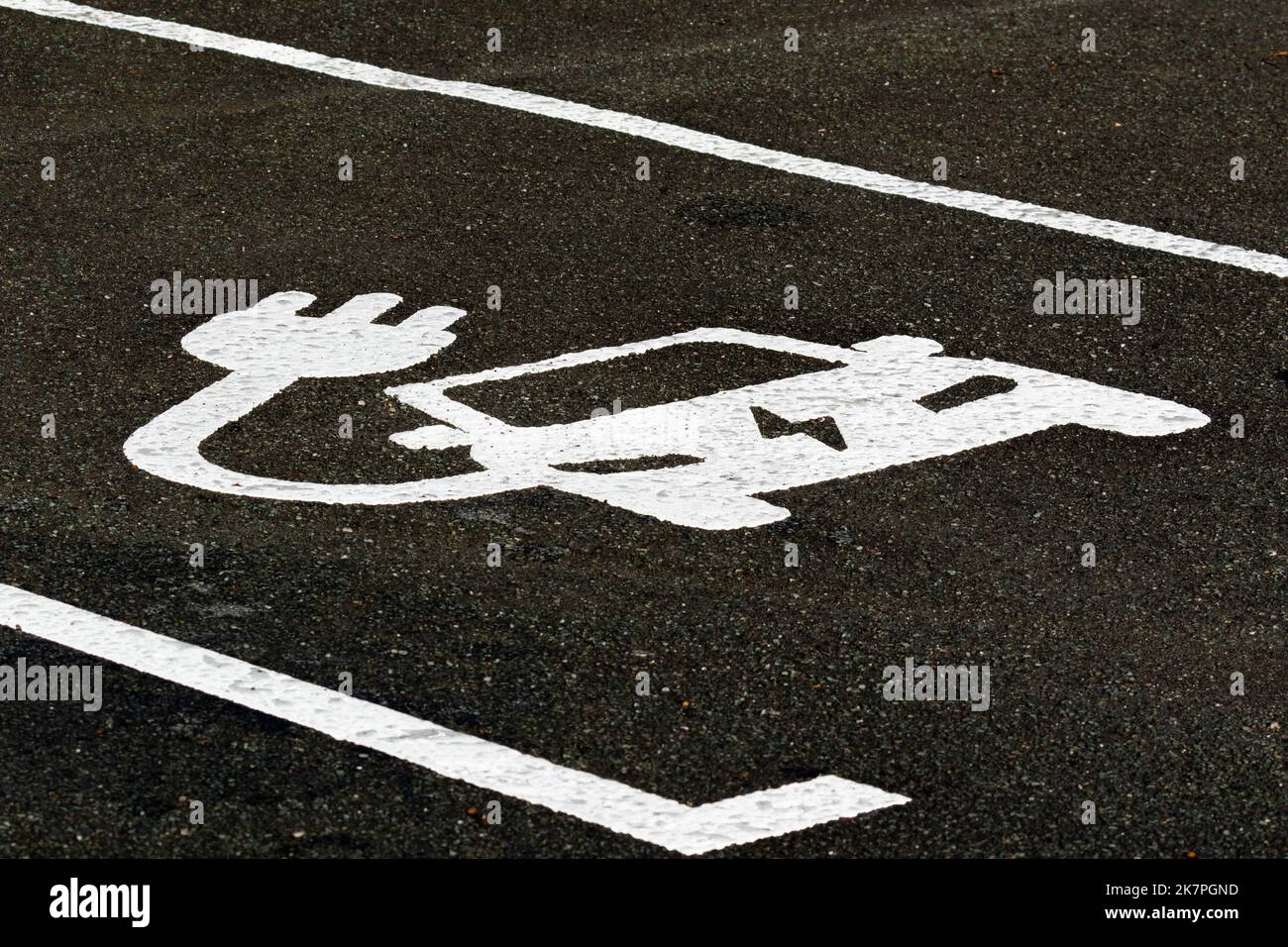 A parking bay marked out for electric vehicle charging. The sign on the ...