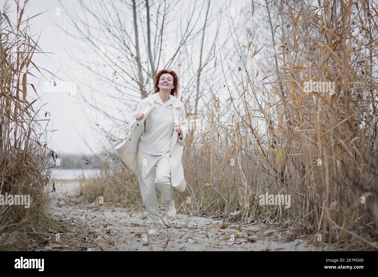 Pretty young woman in trendy white clothes poses in motion Stock Photo ...