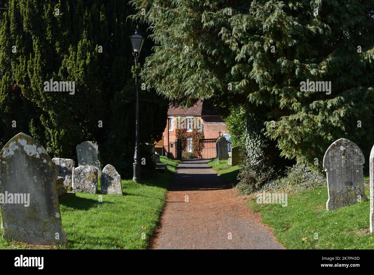 Country path covered by trees leads from a church graveyard through to ...