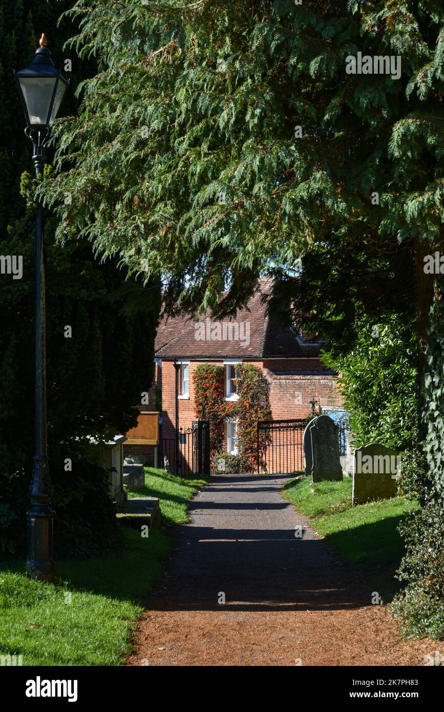 Country path covered by trees leads from a church graveyard through to ...