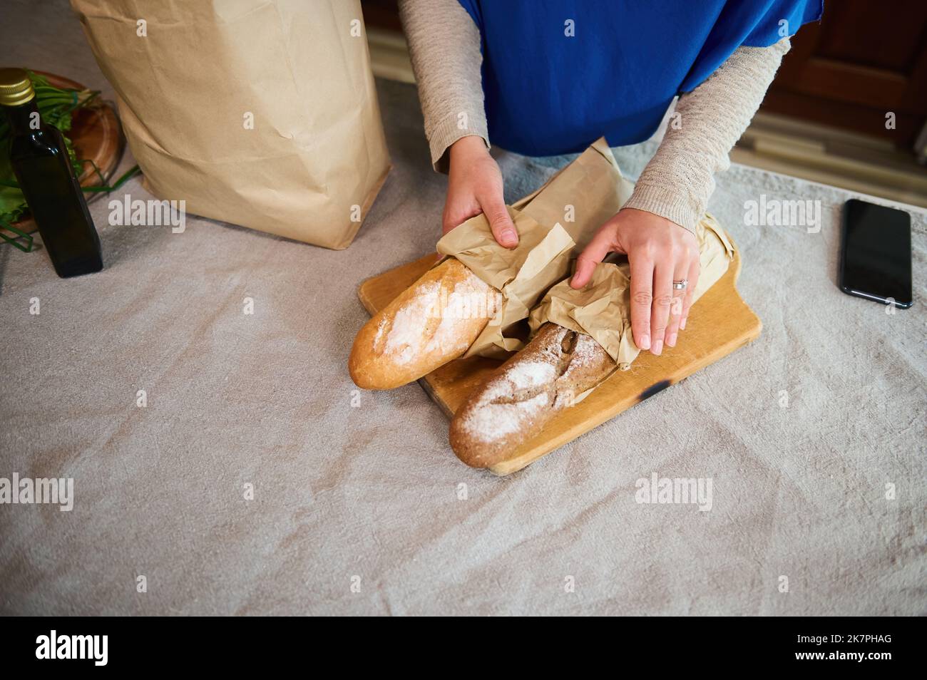 Top view woman's hands on baguettes of sourdough whole grain bread ...