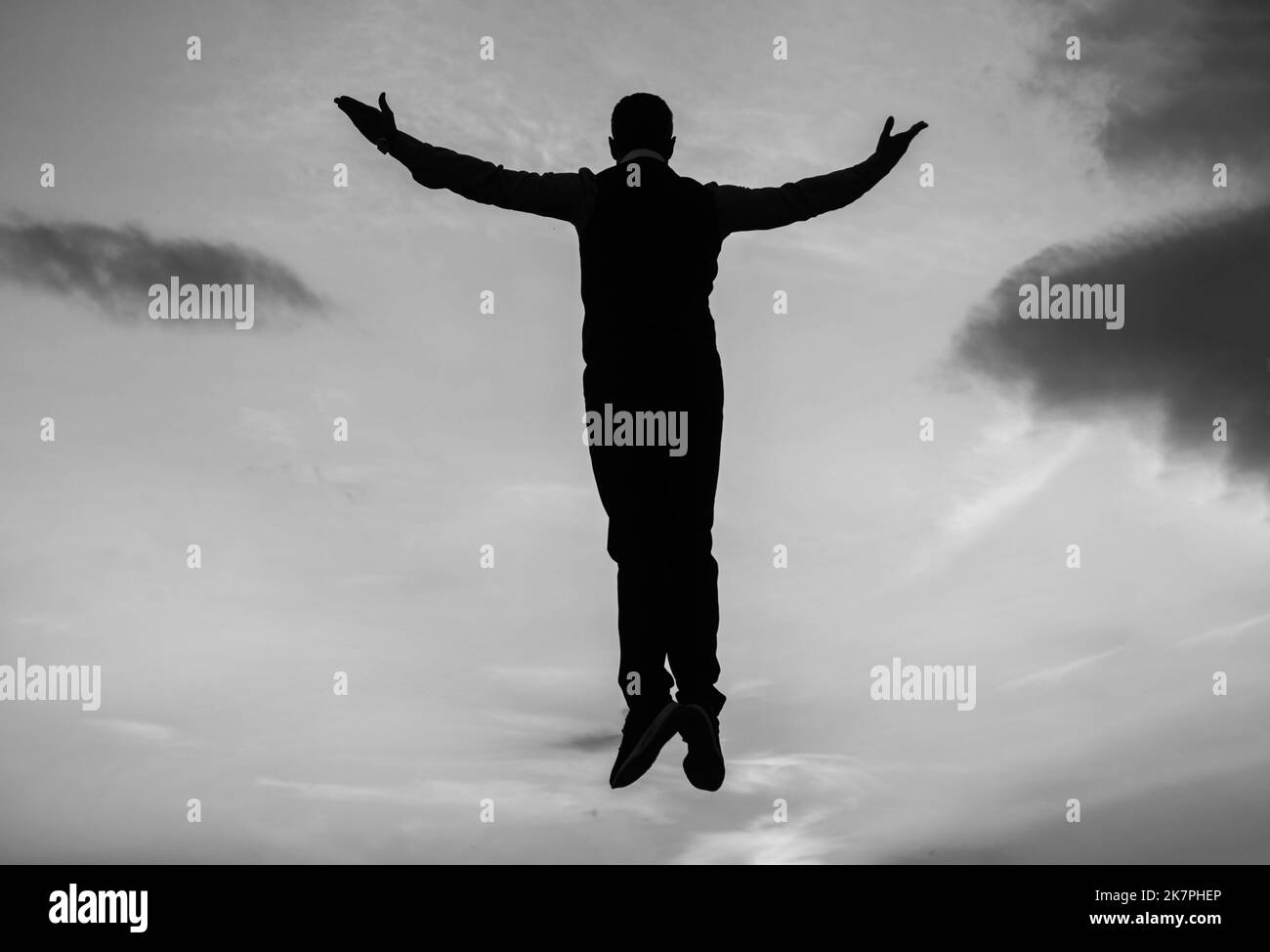 silhouette of man float in sunrise sky with raised hands, freedom Stock ...