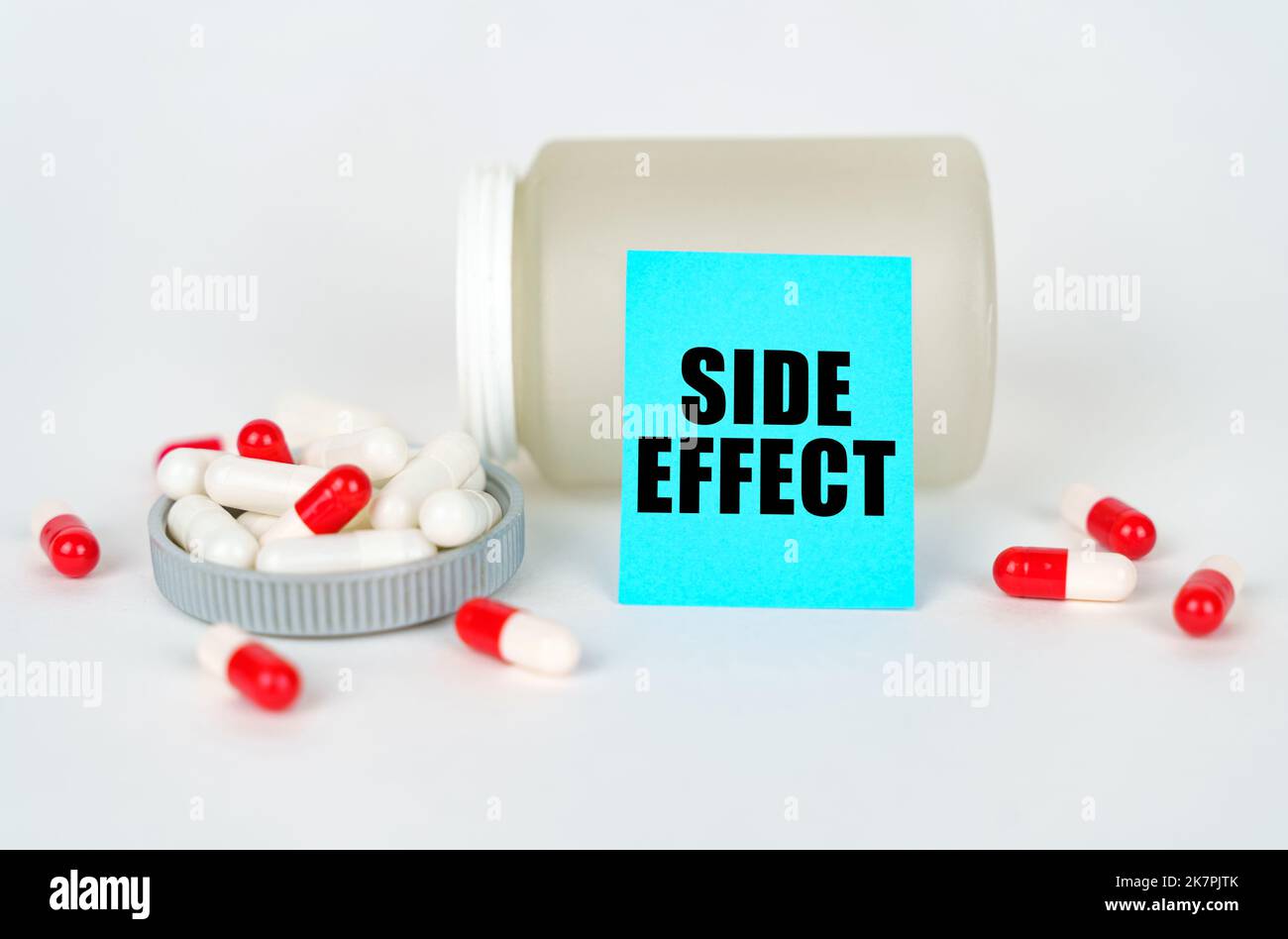 Medical concept. On a gray background, a jar, capsules and a sign with ...