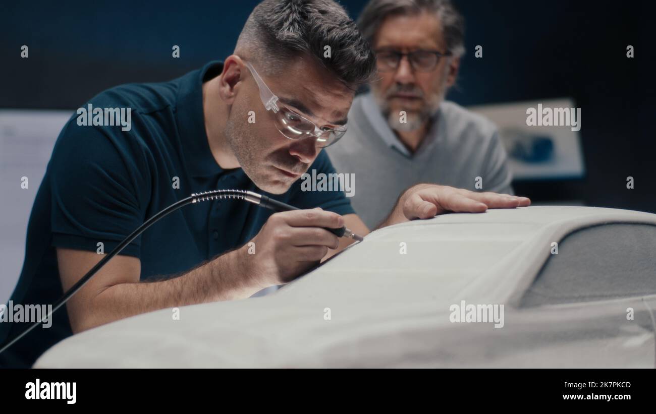 Automotive engineer works on the sculpture of a prototype car model ...