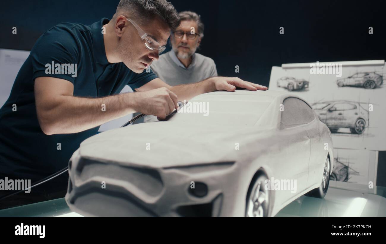 Automotive engineer works on the sculpture of a prototype car model ...