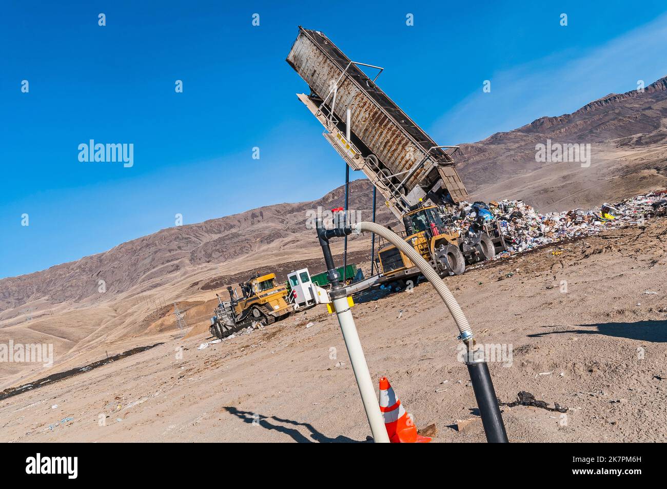 A vertical landfill methane gas well at an active landfill showing a ...