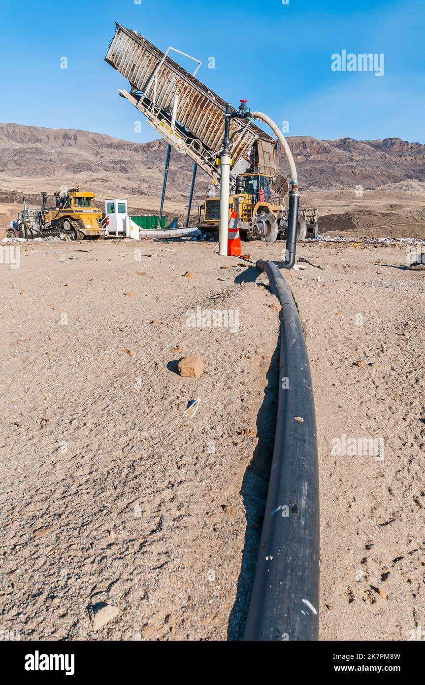 A vertical landfill methane gas well at an active landfill showing a ...
