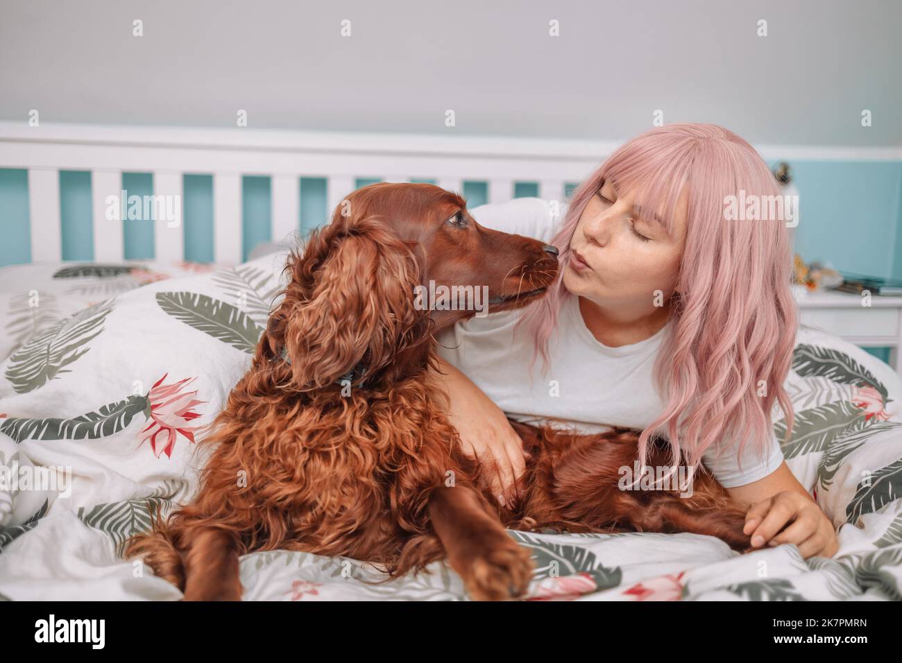 Happy pink hair woman with dog sitting in bed waking up happy concept ...