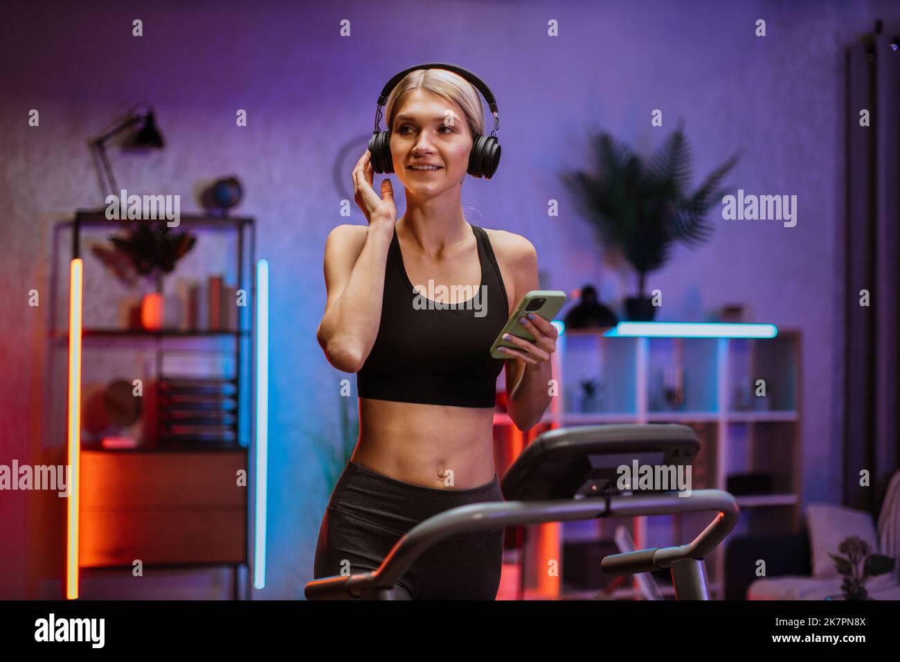 Attractive young sports caucasian woman listening music doing fitness ...