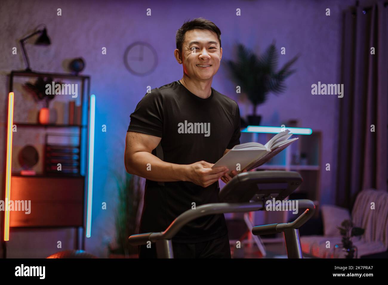 Attractive young sports asian man reading book working out, running ...
