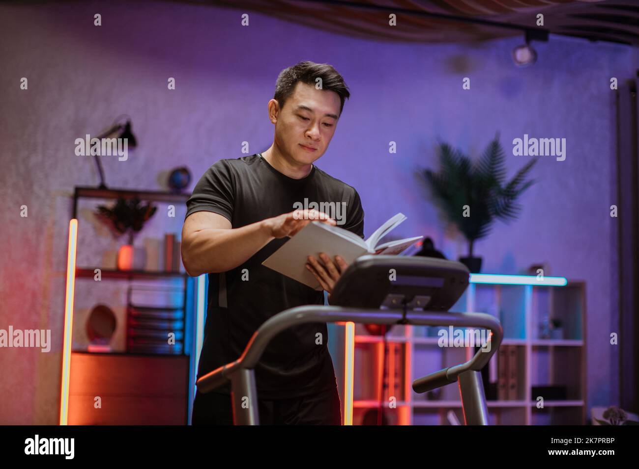 Attractive young sports asian man reading book while doing fitness ...