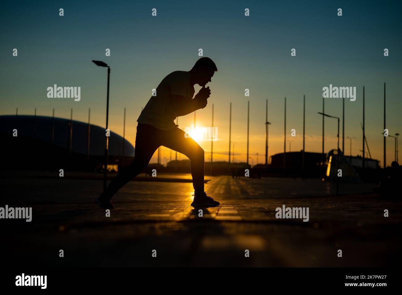 A man trains boxing at sunset outdoors Stock Photo - Alamy
