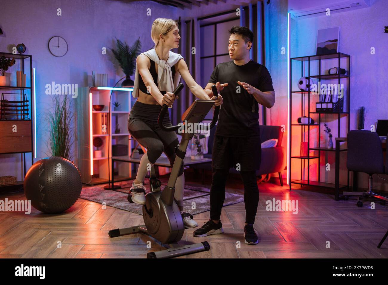 Beautiful blond caucasian sports women in sportswear cycling bike ...