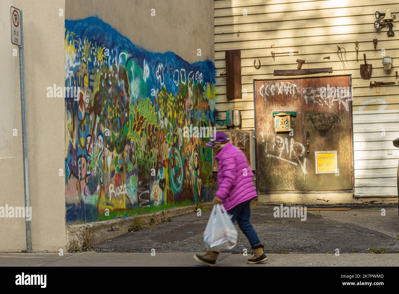 A woman walks by a decaying building in the Quebec city district of St ...