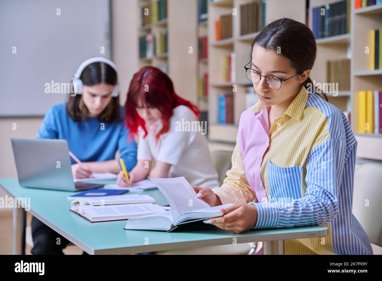 High school students studying in library class, teenage girl in focus ...