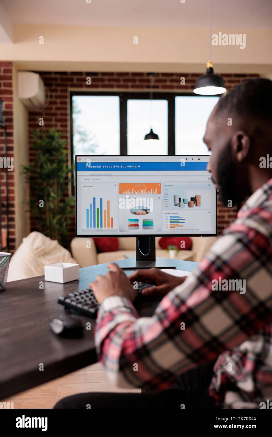 Young adult analyzing business charts on computer monitor, working with ...