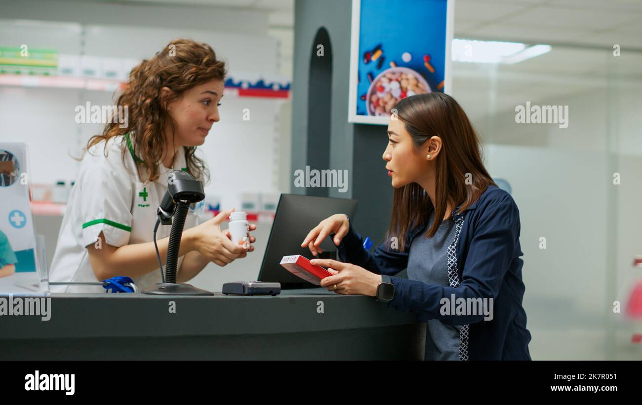 Female client talking to pharmacist about cardiology pills, showing ...