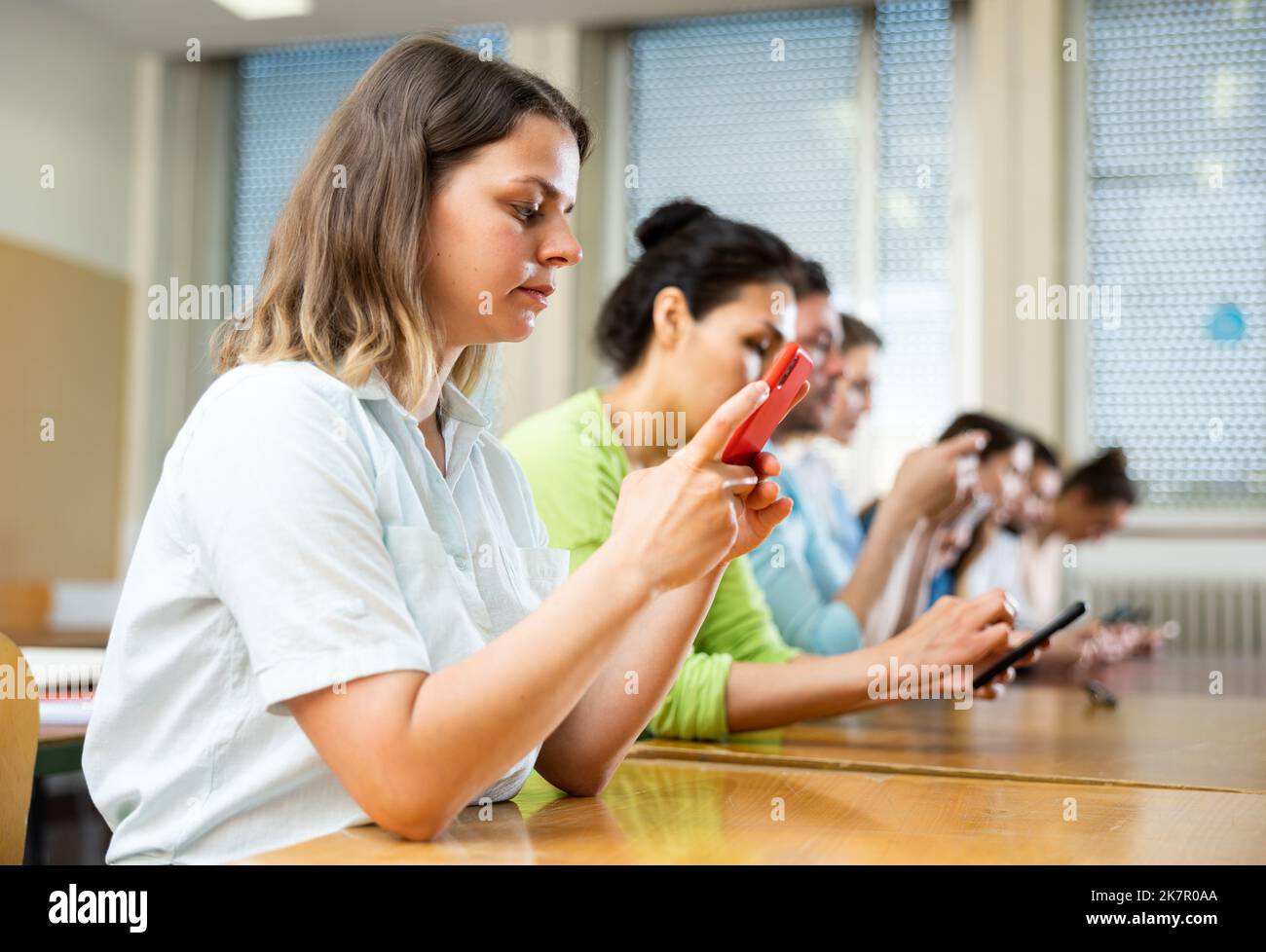 Portrait of students using mobile phones during lesson Stock Photo - Alamy